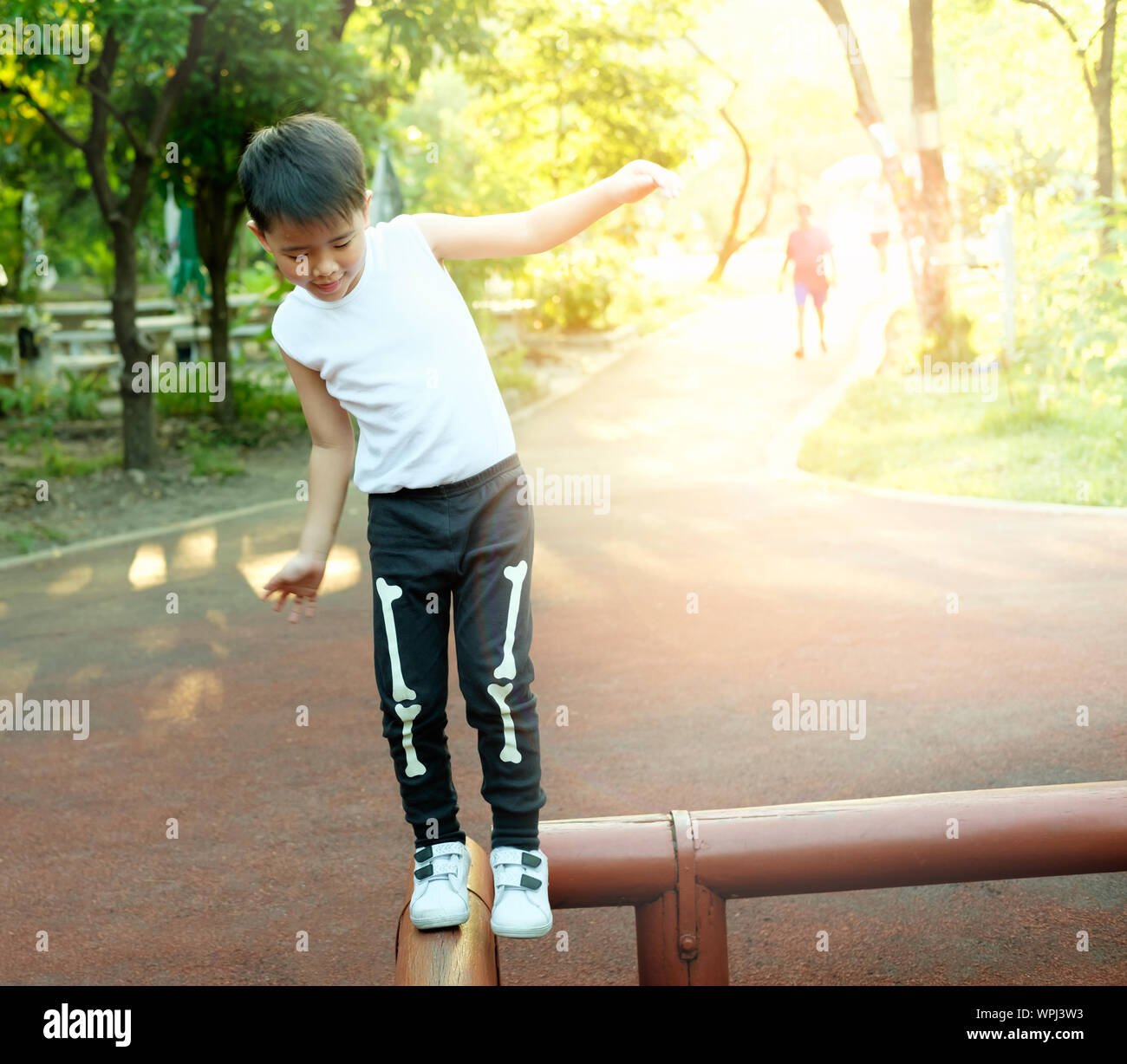 Asian boy balancing on timber In the park Stock Photo - Alamy