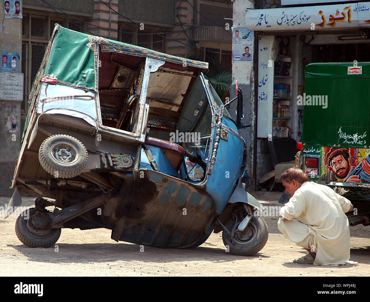 A mechanic fixes a problem with his rickshaw in Peshawar, Pakistan. It ...