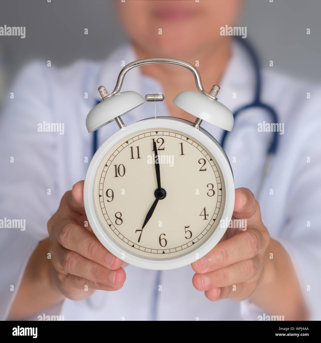 Doctor is holding alarm clock to show punctuality. Time concept Stock ...