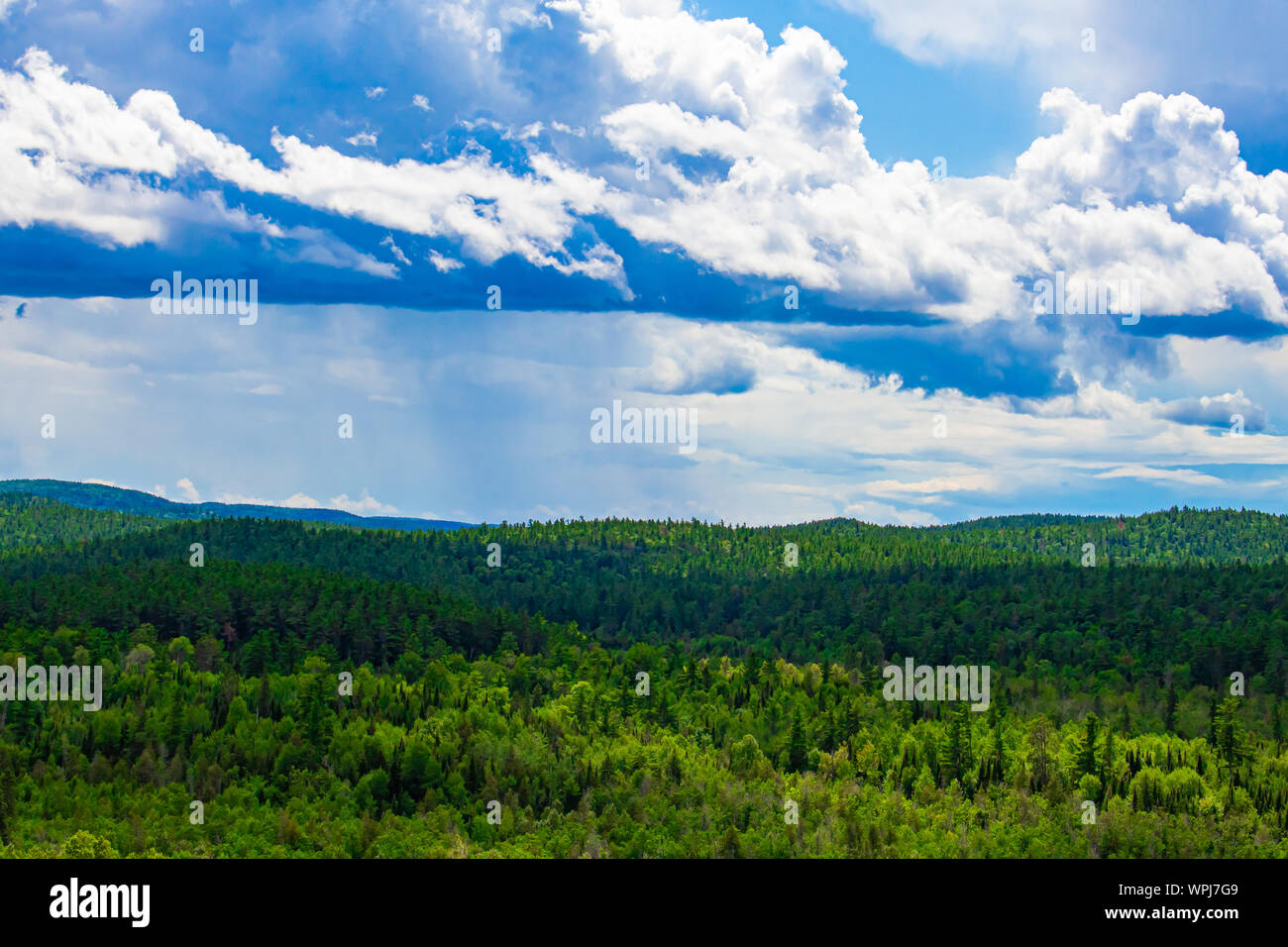 A view of rolling forest hills in Ontario, Canada on a partly cloudy ...