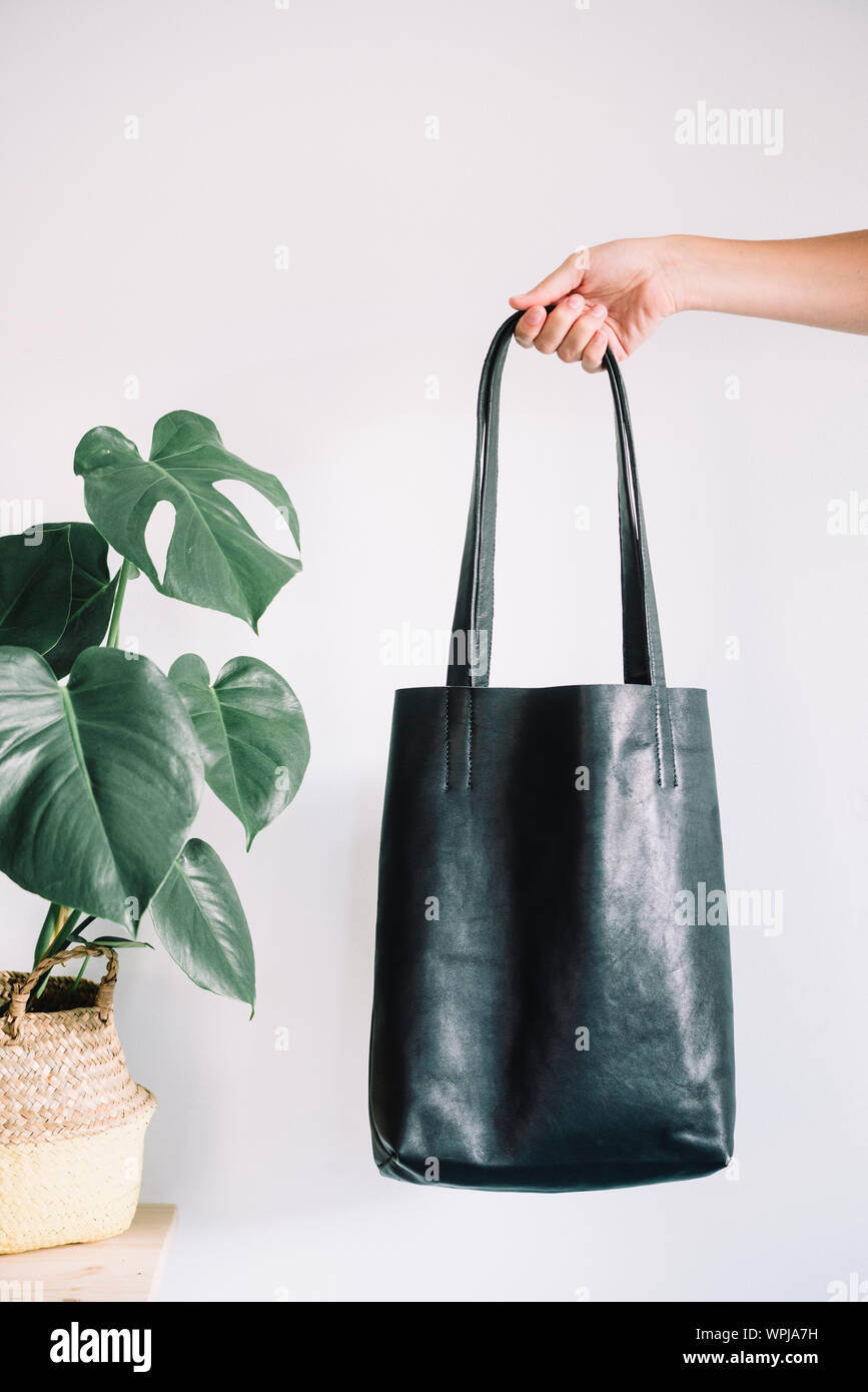 Girl holding her black leather tote bag Stock Photo - Alamy