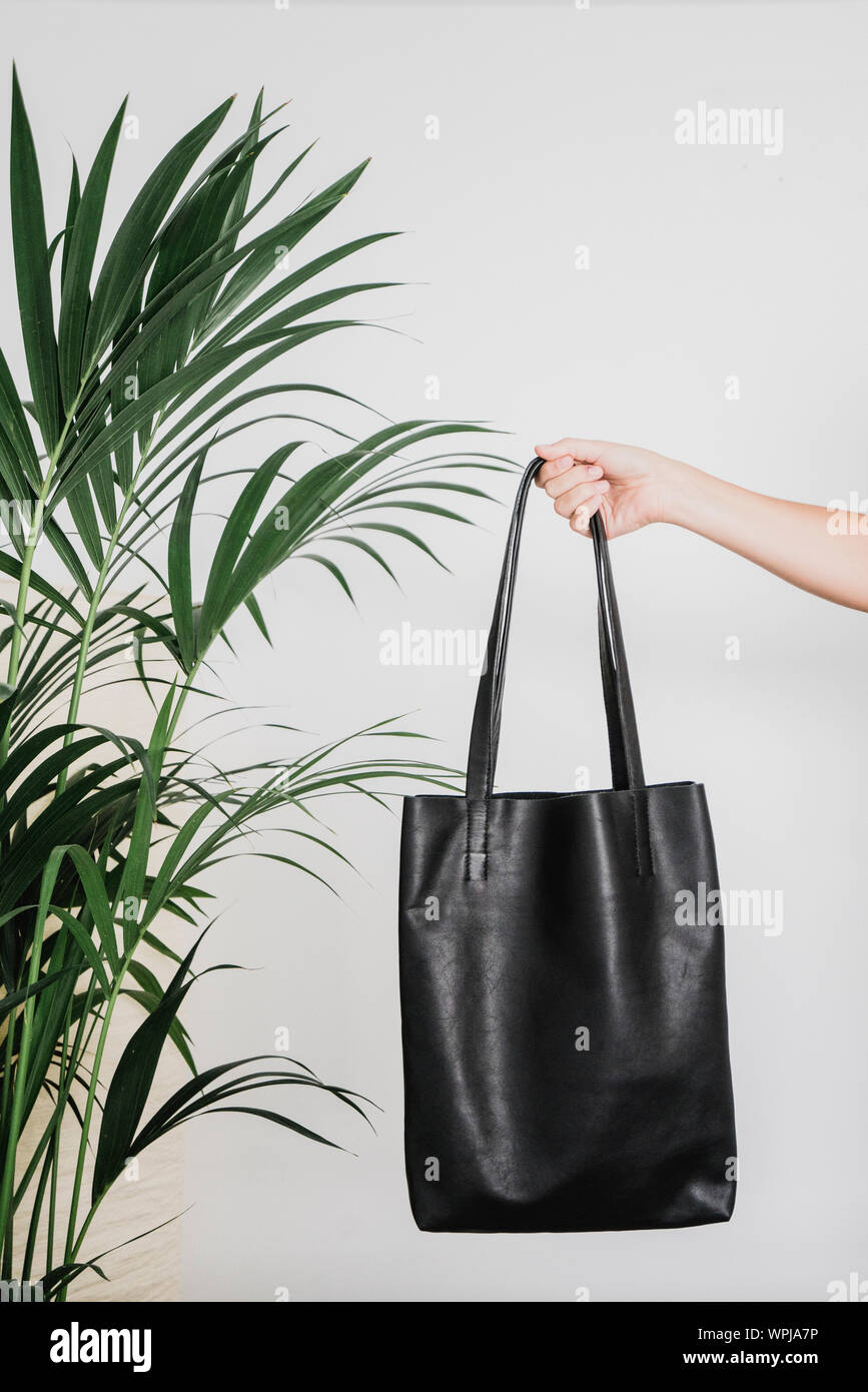 Girl holding her black leather tote bag Stock Photo - Alamy