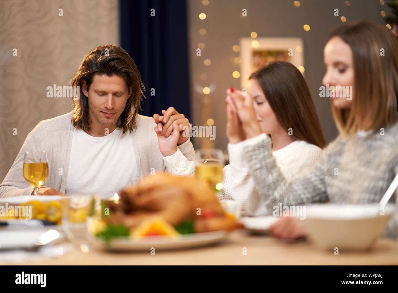 Beautiful family praying over festive dinner at home Stock Photo - Alamy