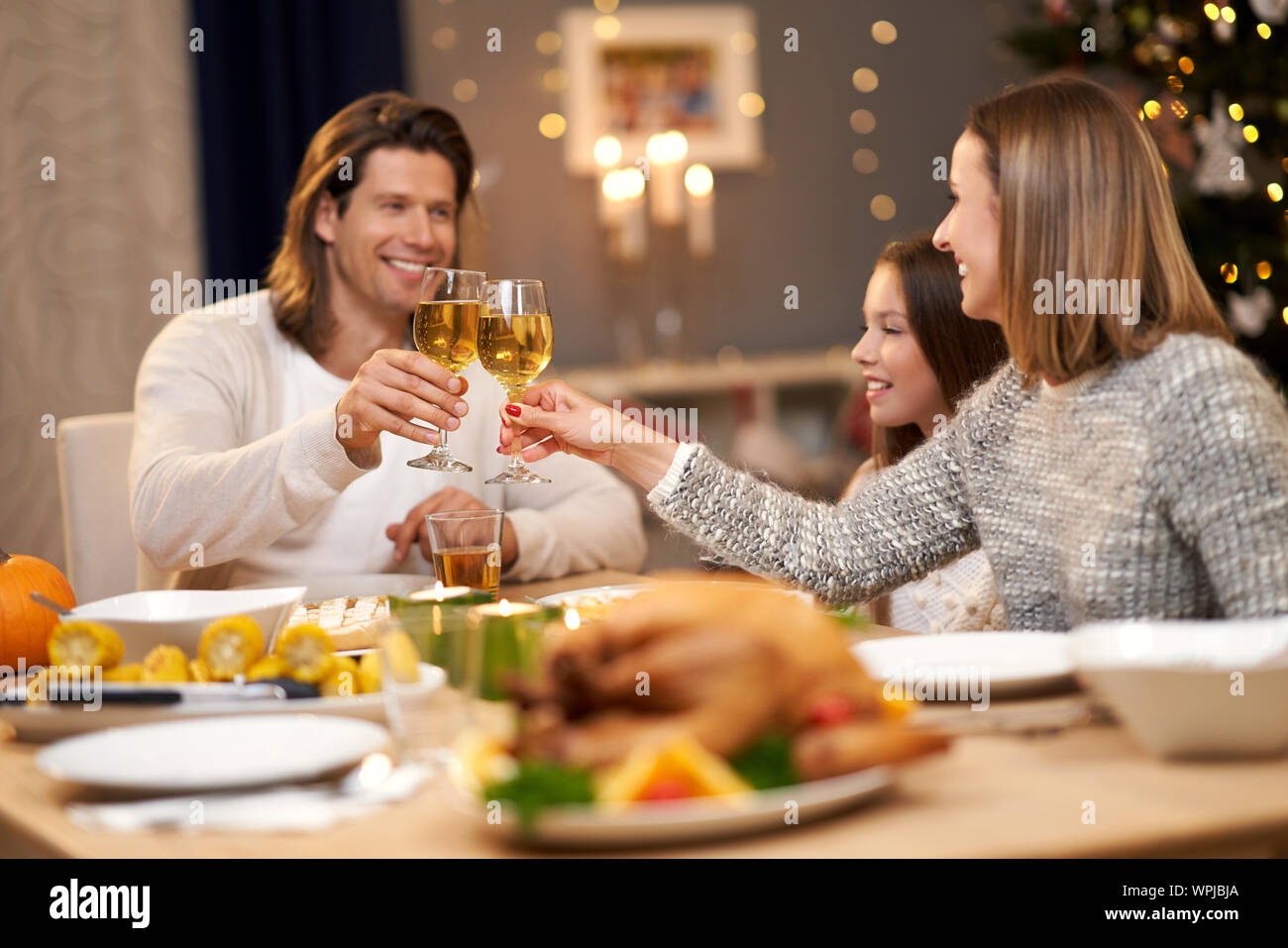 Beautiful family eating Christmas dinner at home Stock Photo - Alamy