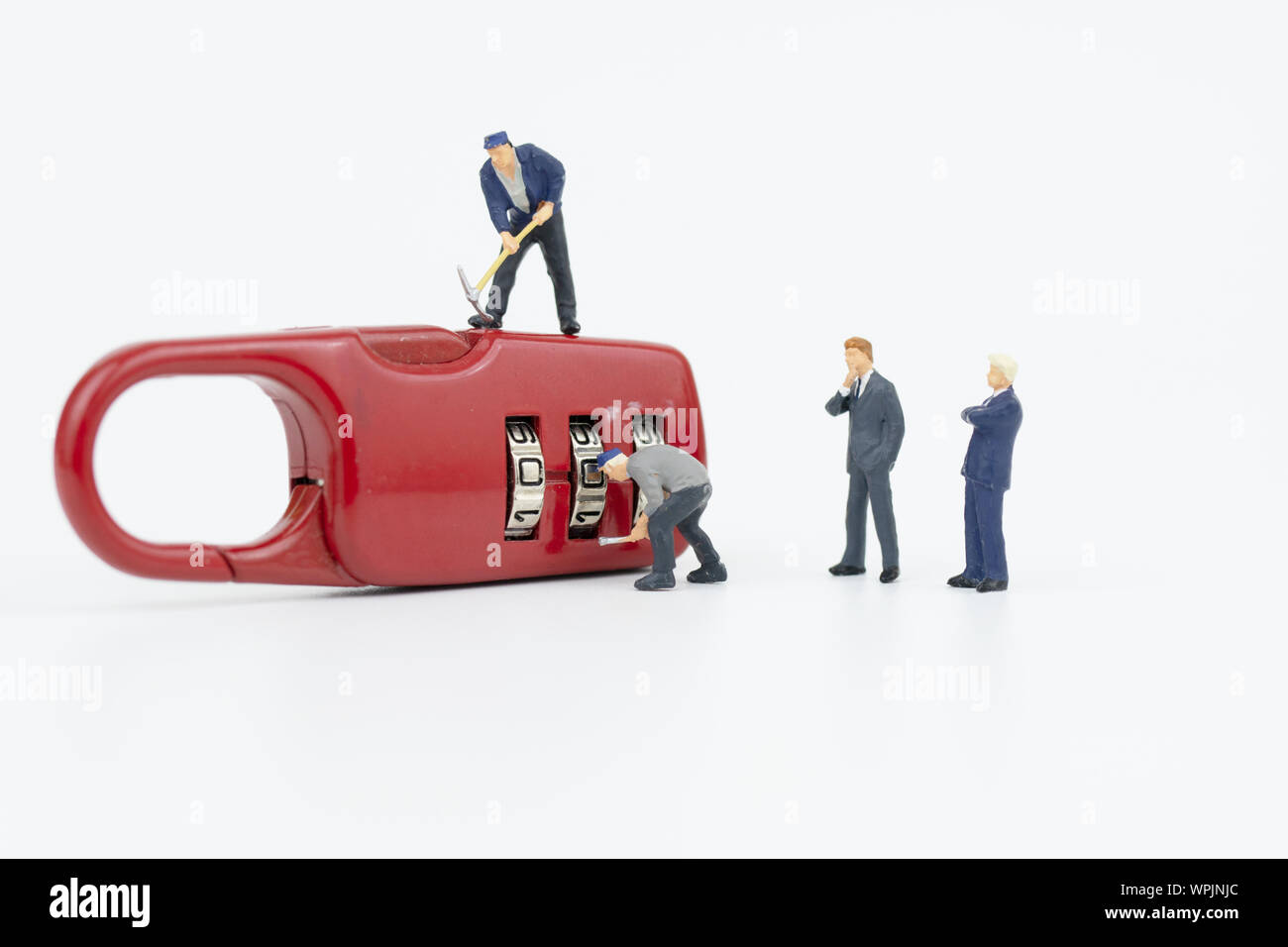 Miniature people try to unlock key,security concept Stock Photo - Alamy