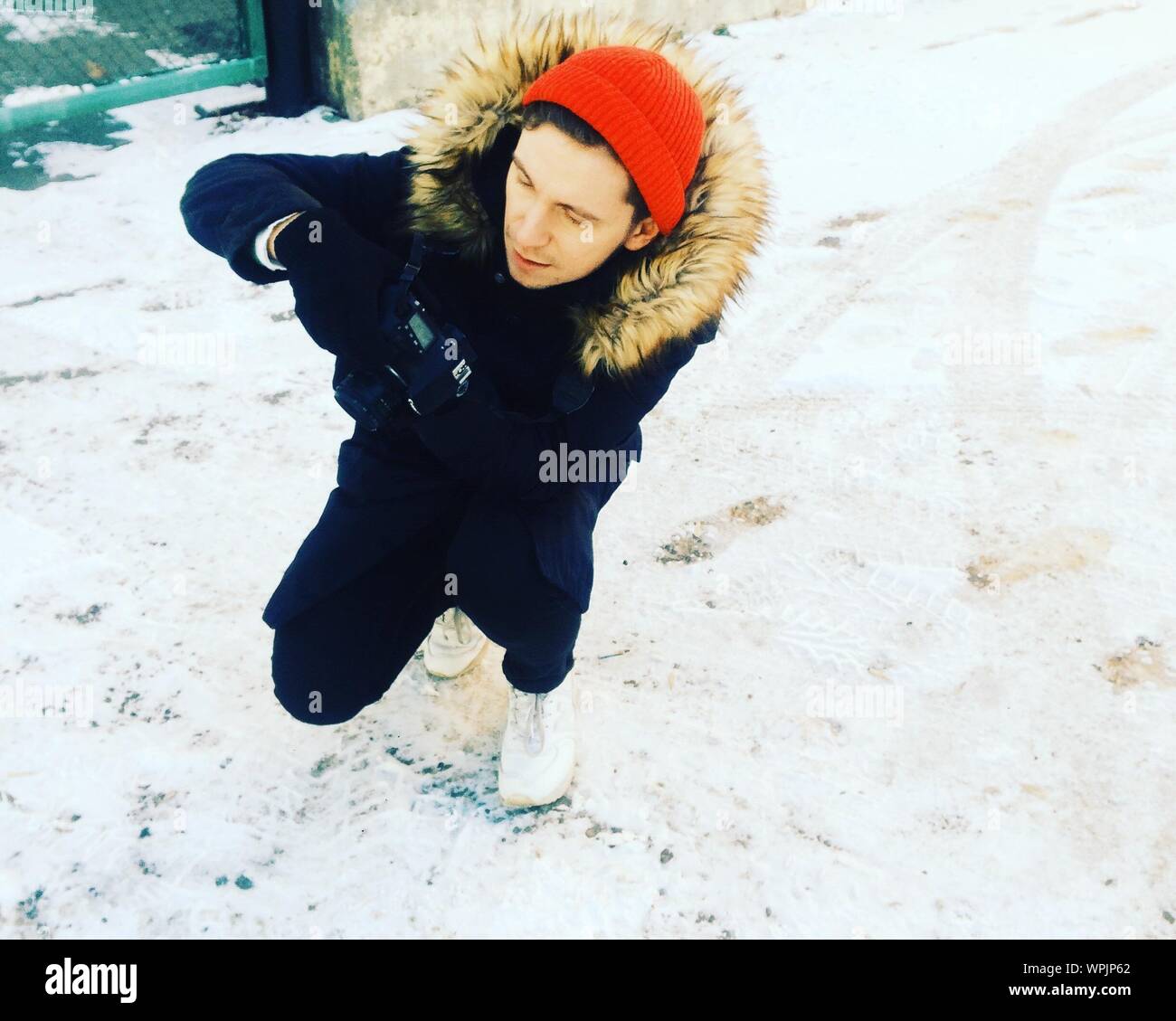 Full Length Of Man Crouching On Snow Stock Photo - Alamy