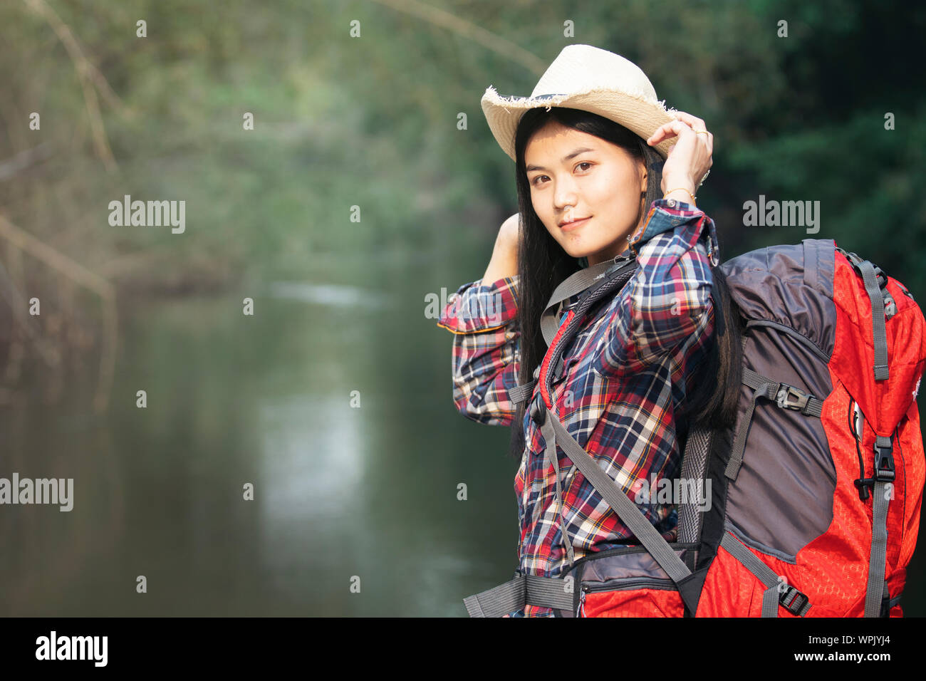 Backpacker woman with nature background Stock Photo - Alamy