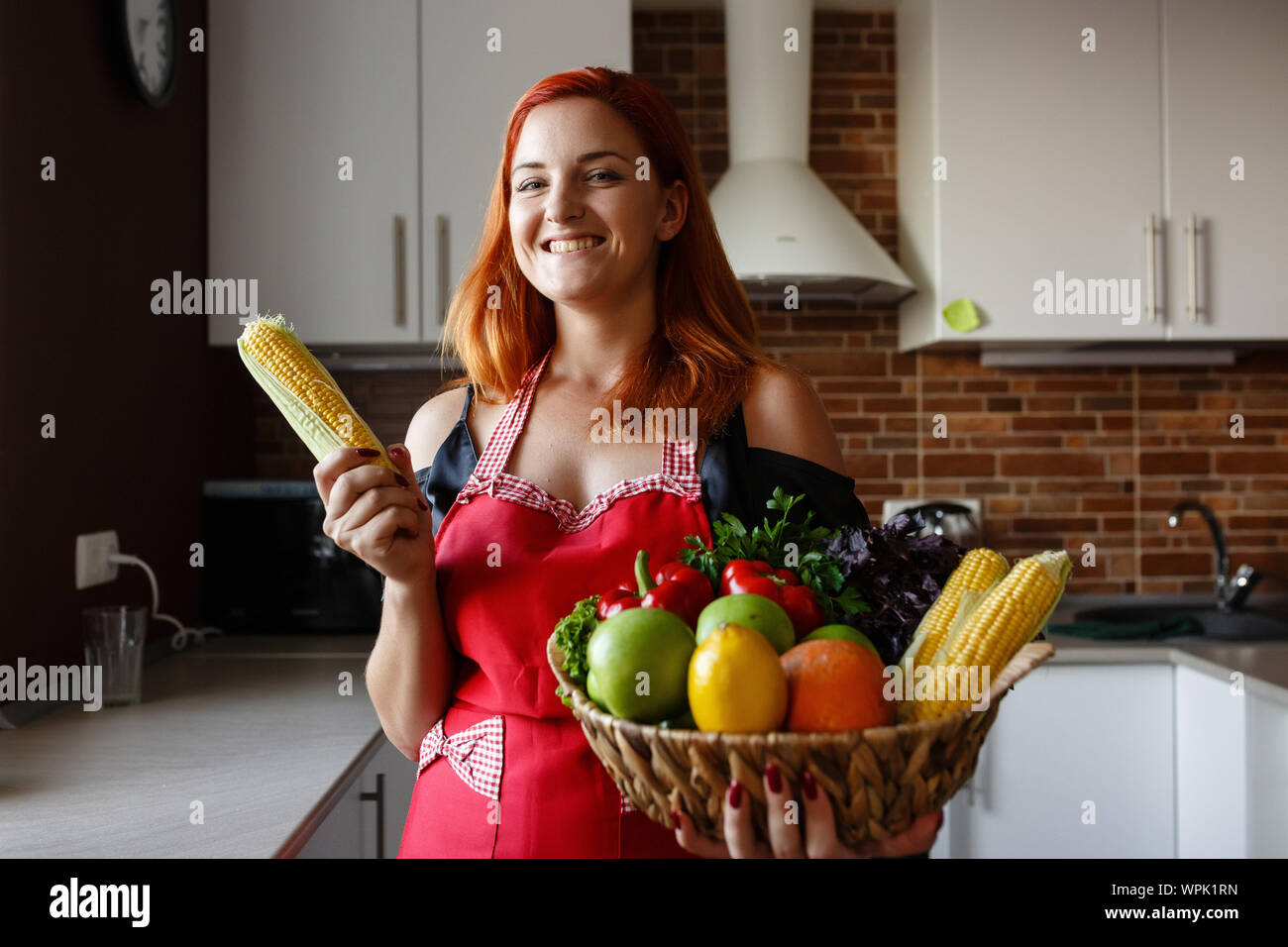 Photo of young pretty lady standing in kitchen while cooking fish ...