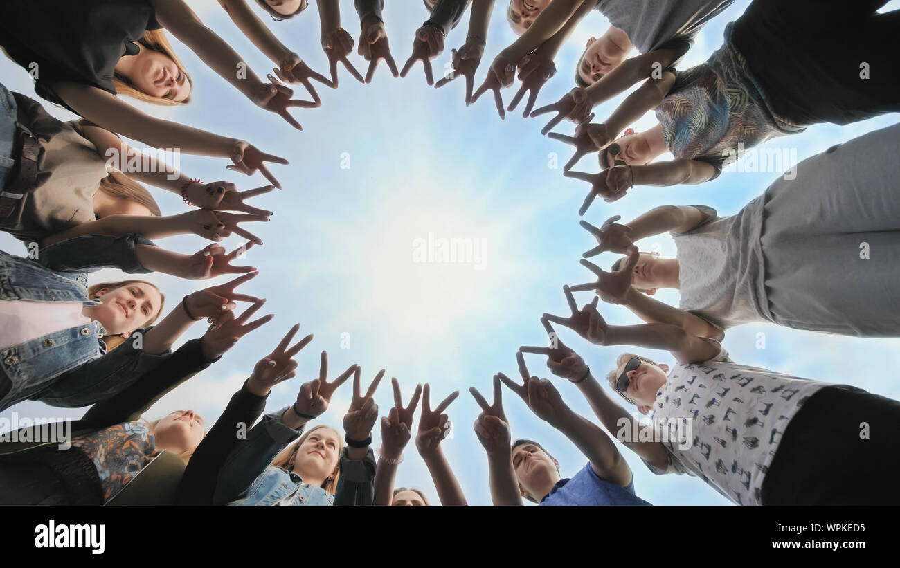 A group of friends make a circle out of their fingers. The concept of ...