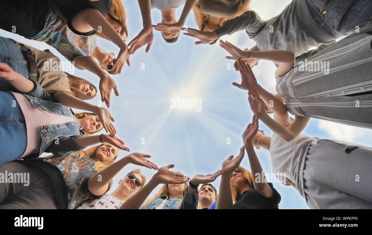 A large group of students makes a circle out of their hands Stock Photo ...