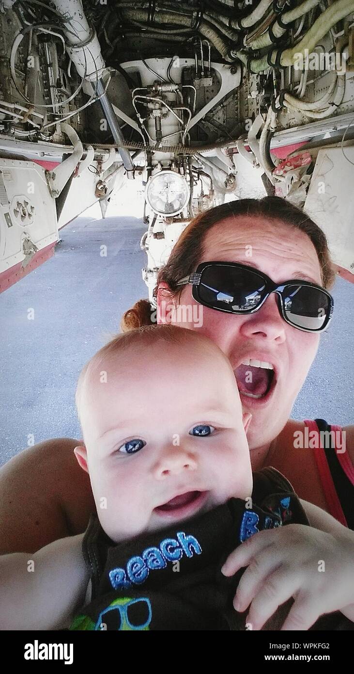 Portrait Of Mother With Baby Under Fighter Plane At Airport Runway ...