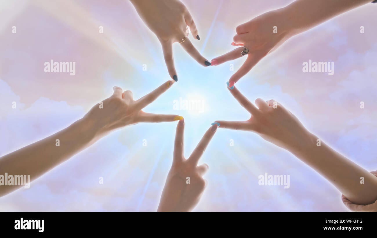 People forming star shape with their fingers against the backdrop of a ...