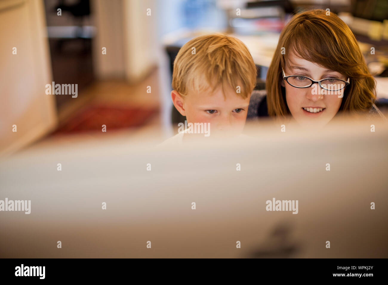 Young boy and his mother looking at a computer monitor Stock Photo - Alamy