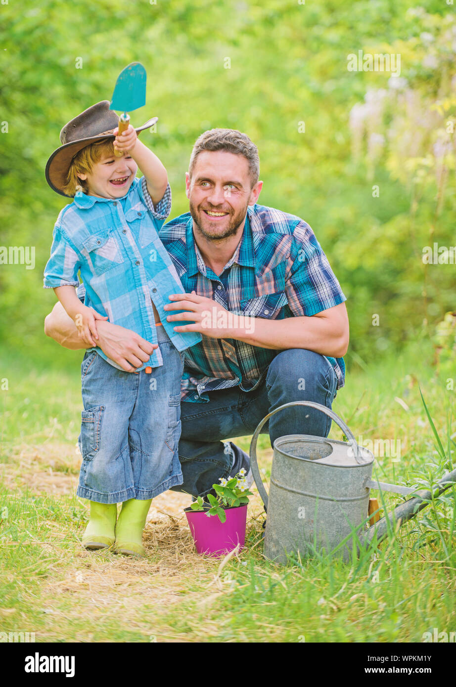 small boy child help father in farming. watering can, pot and hoe ...