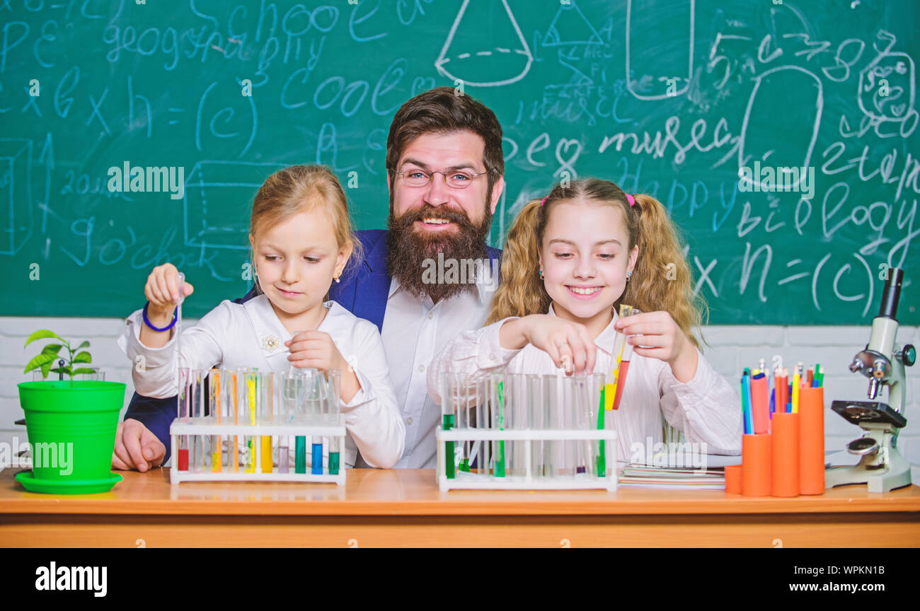 Research studies. Science teacher and pupils doing research work ...