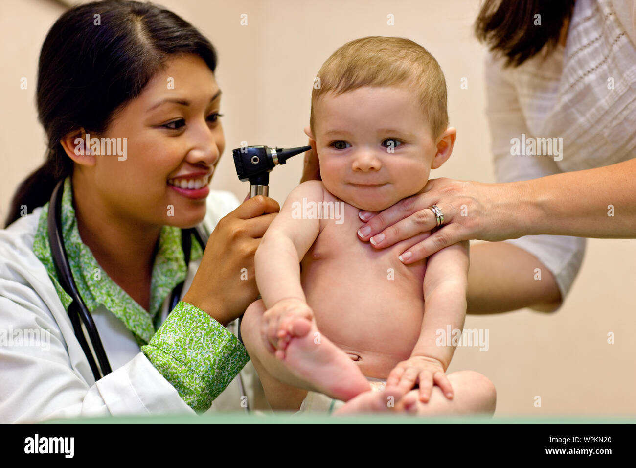 Doctor examining baby boy's ear with otoscope Stock Photo - Alamy