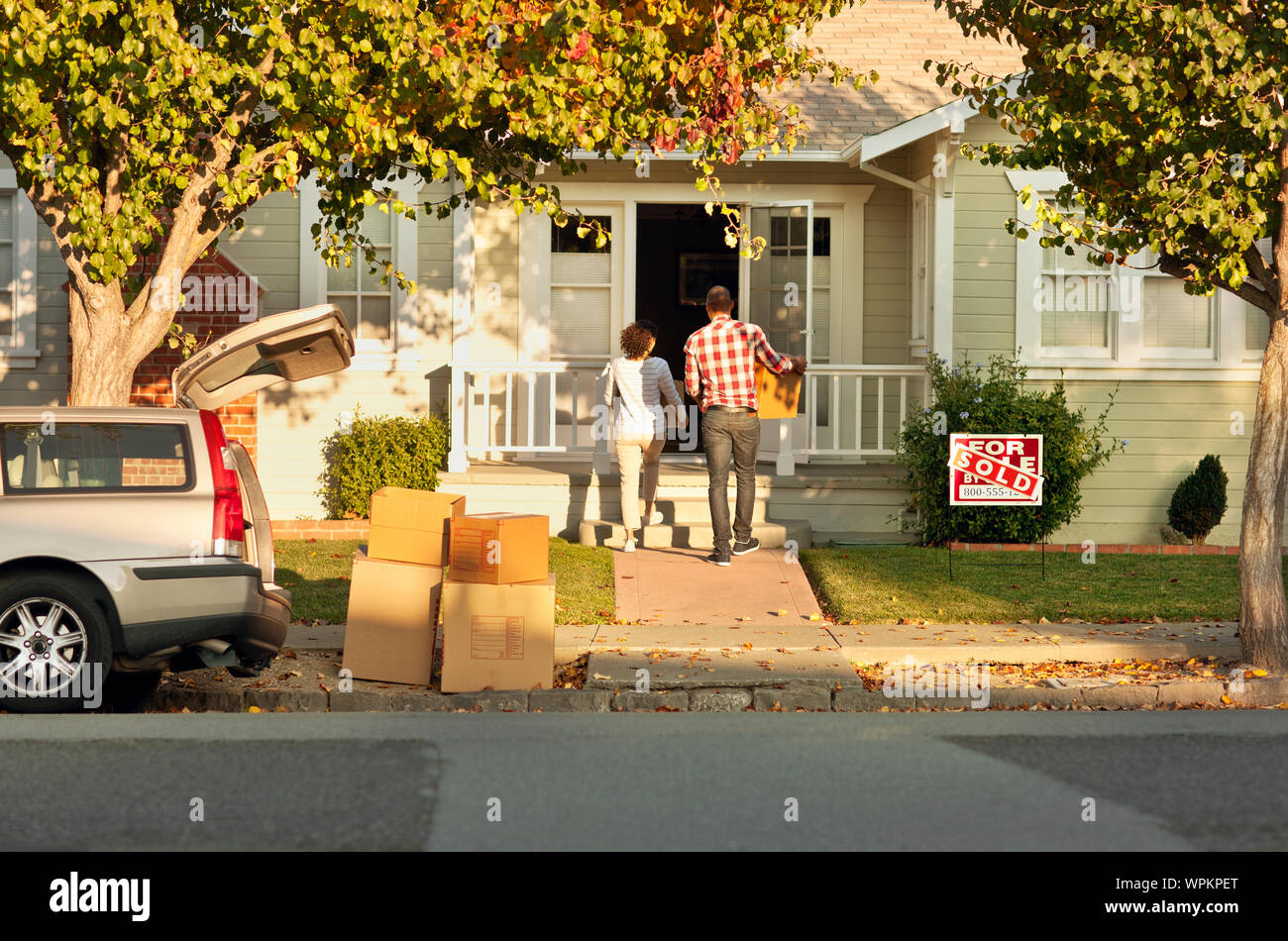 Couple arrive with boxes at their new home Stock Photo - Alamy