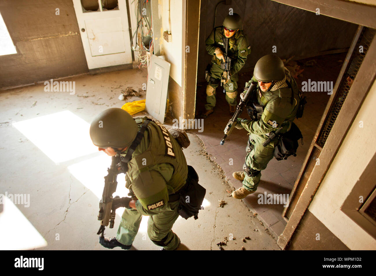 Three police officers inside a building during an exercise at training ...