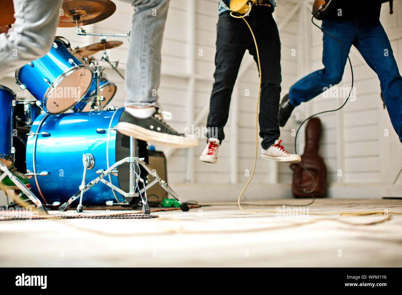 Legs of three teenage boys jumping in mid air inside a garage while ...