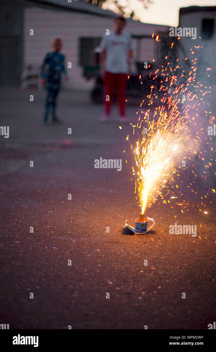 Two people watching fireworks go off on a driveway Stock Photo - Alamy