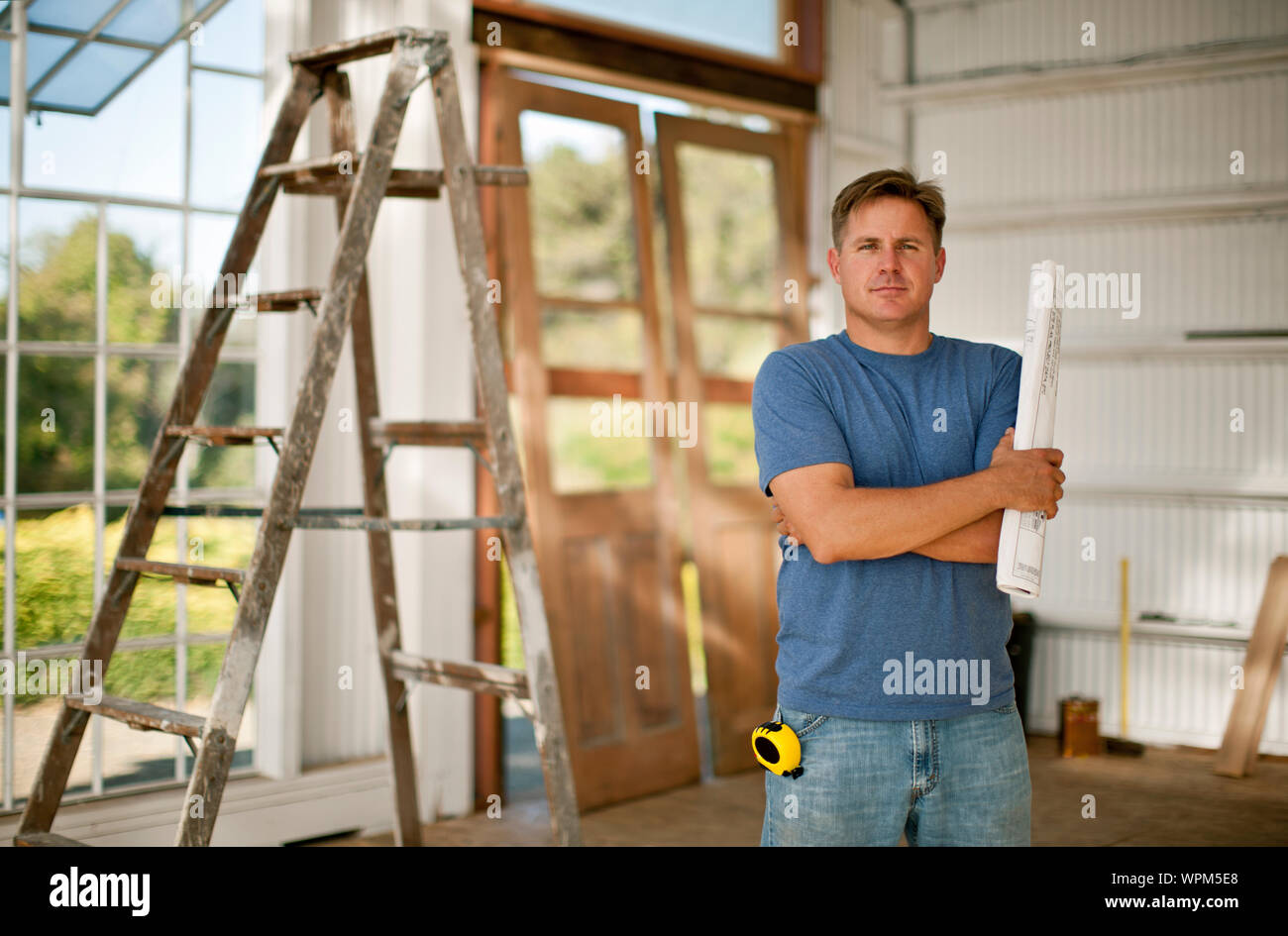 Construction worker writing on a blueprint while a businessman looks on ...