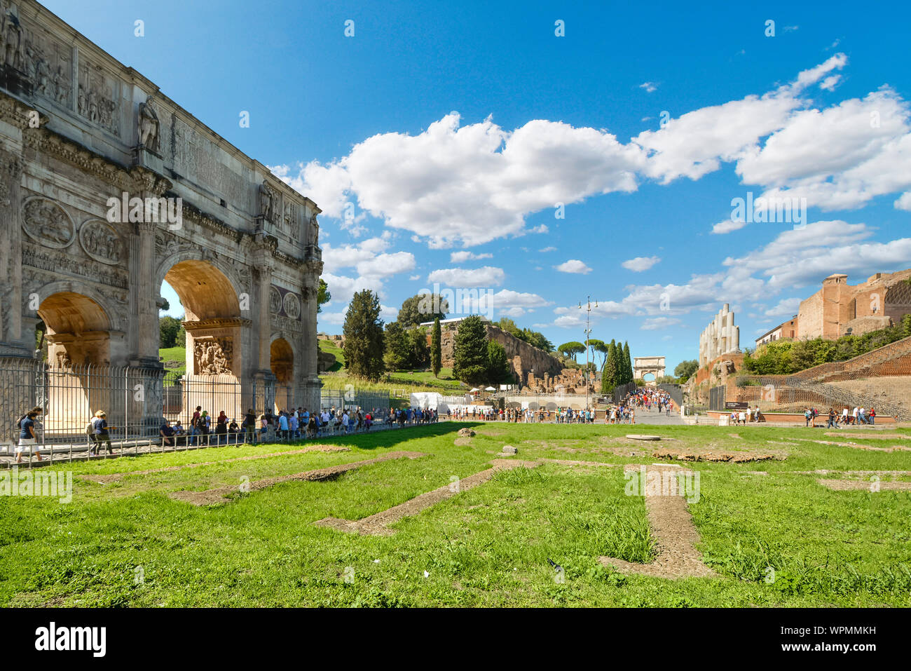 Tourists visit the Roman Forum, with the Arch of Constantine and Arch ...