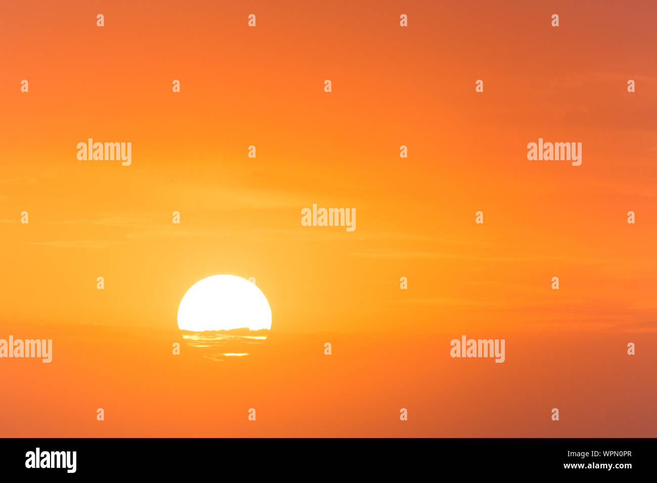 view on sun rising behind slight clouds Stock Photo - Alamy