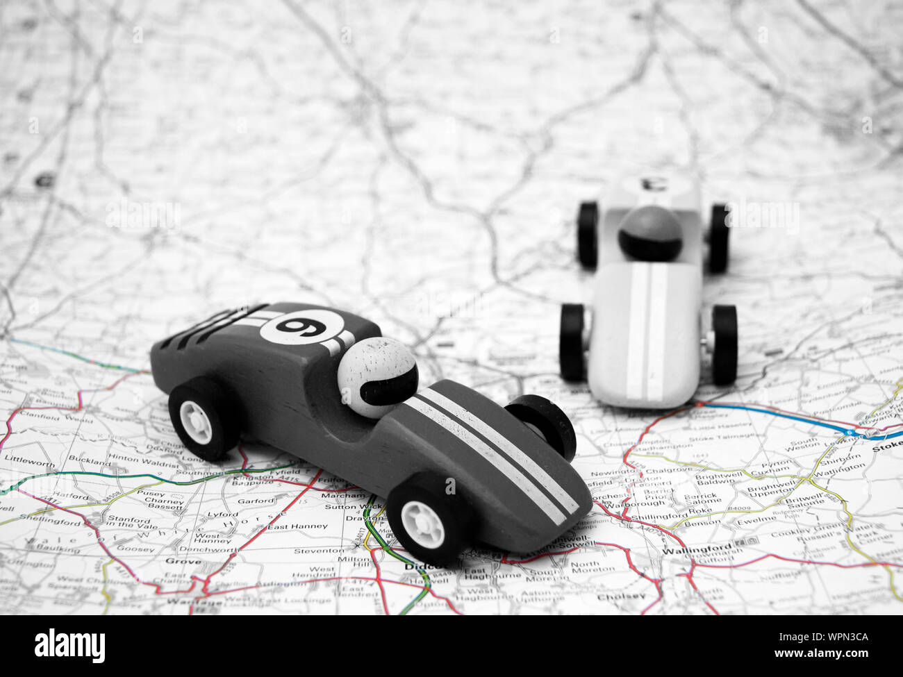Toy racing cars on a road map Stock Photo - Alamy