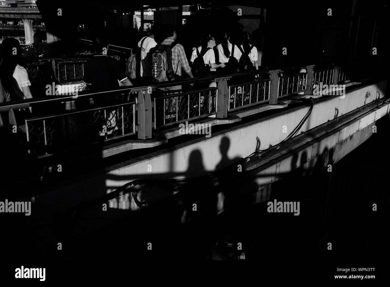 Sunlight Falling On People Walking Over Bridge Stock Photo - Alamy