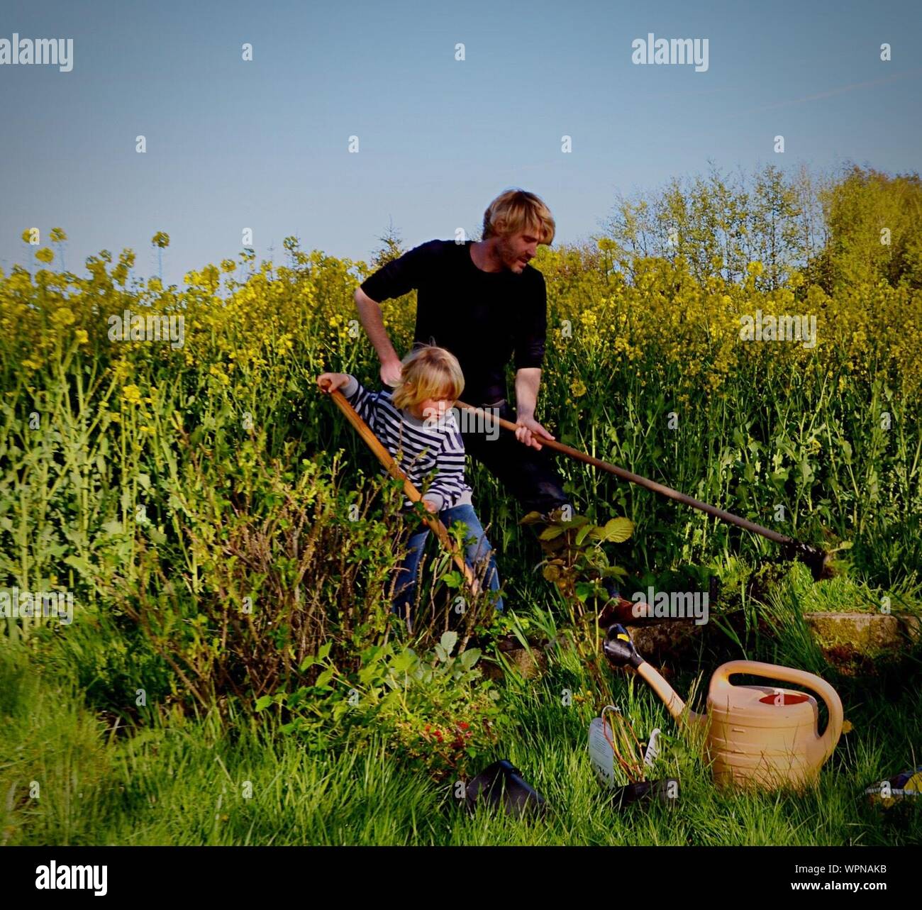 Father son watering plant in hi-res stock photography and images - Alamy