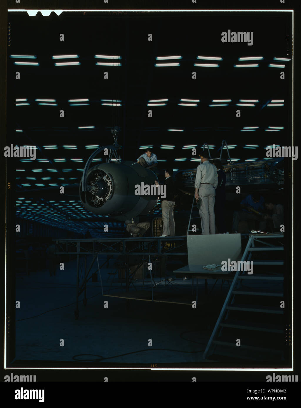 Lowering an engine in place in assembling a transport plane in a ...