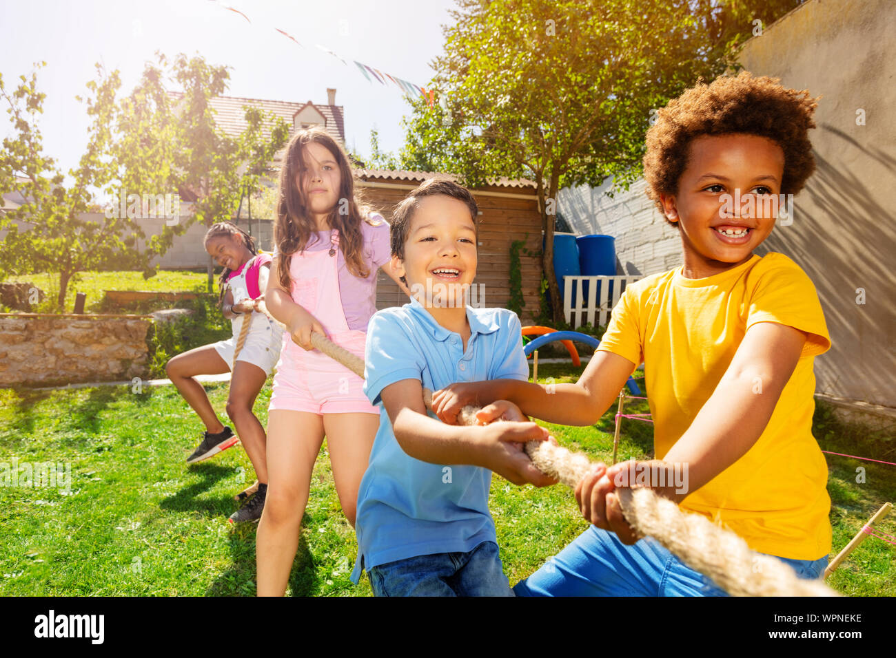 Group of kids play pulling rope game on playground Stock Photo - Alamy