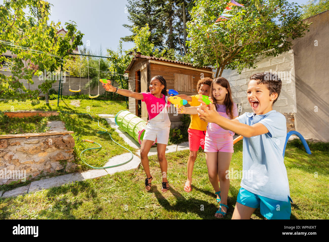 Kids play water gun fight in a team with friends Stock Photo - Alamy