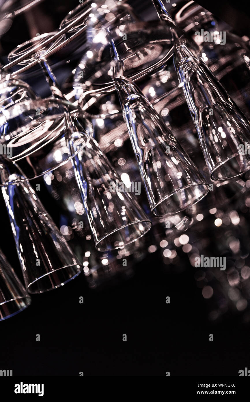 Glass cups hanging from bar ceiling Stock Photo - Alamy