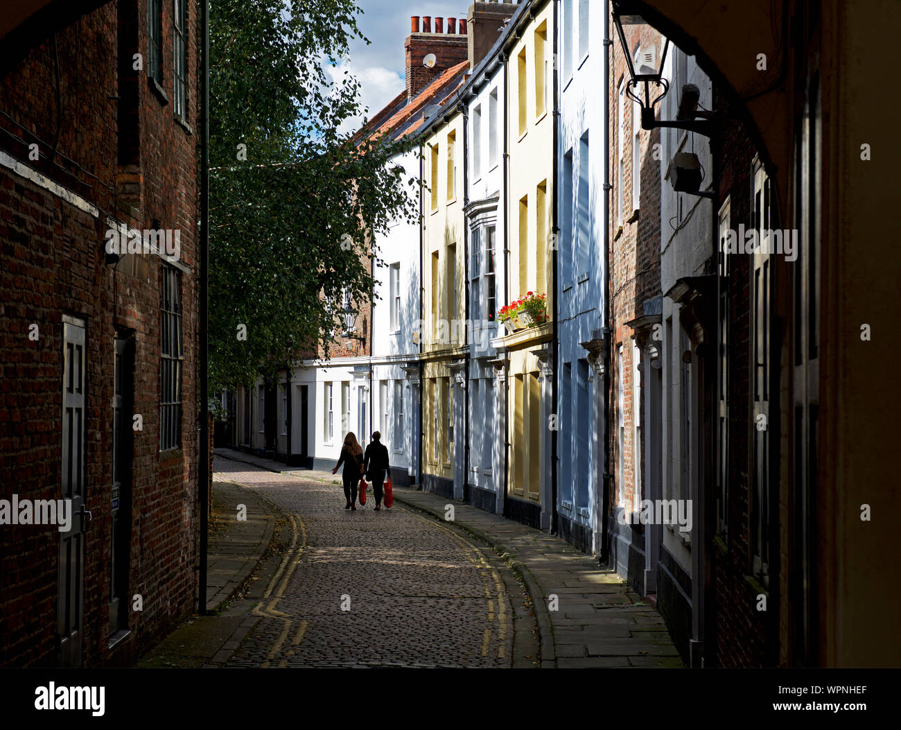 Two young women walking past the Georgian Houses on cobbled Prince ...