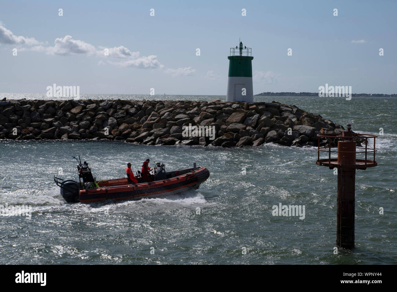 A ship leaves the port between two lighthouses Stock Photo - Alamy