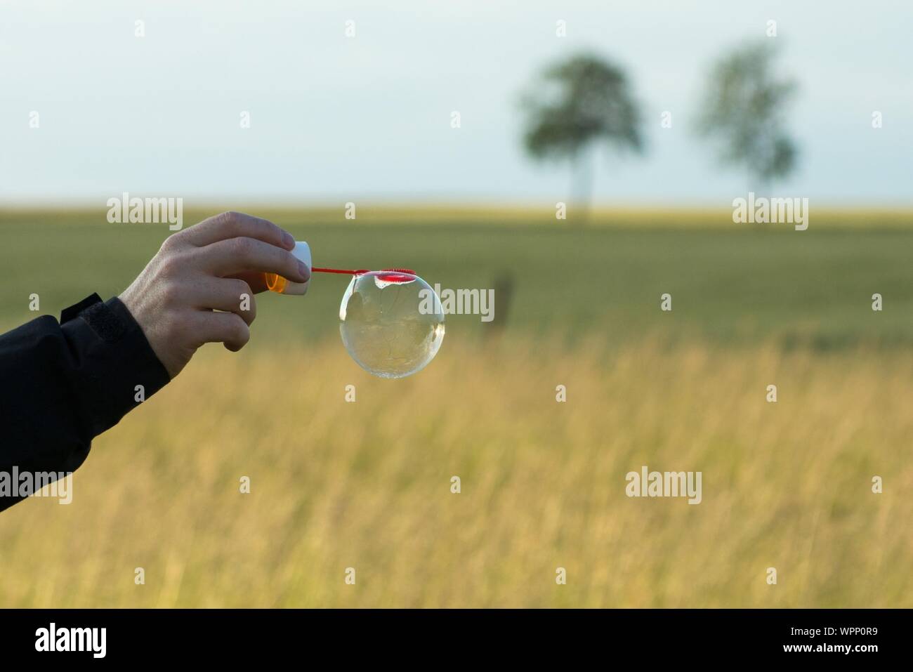 Hand holding bubble wand hi-res stock photography and images - Alamy