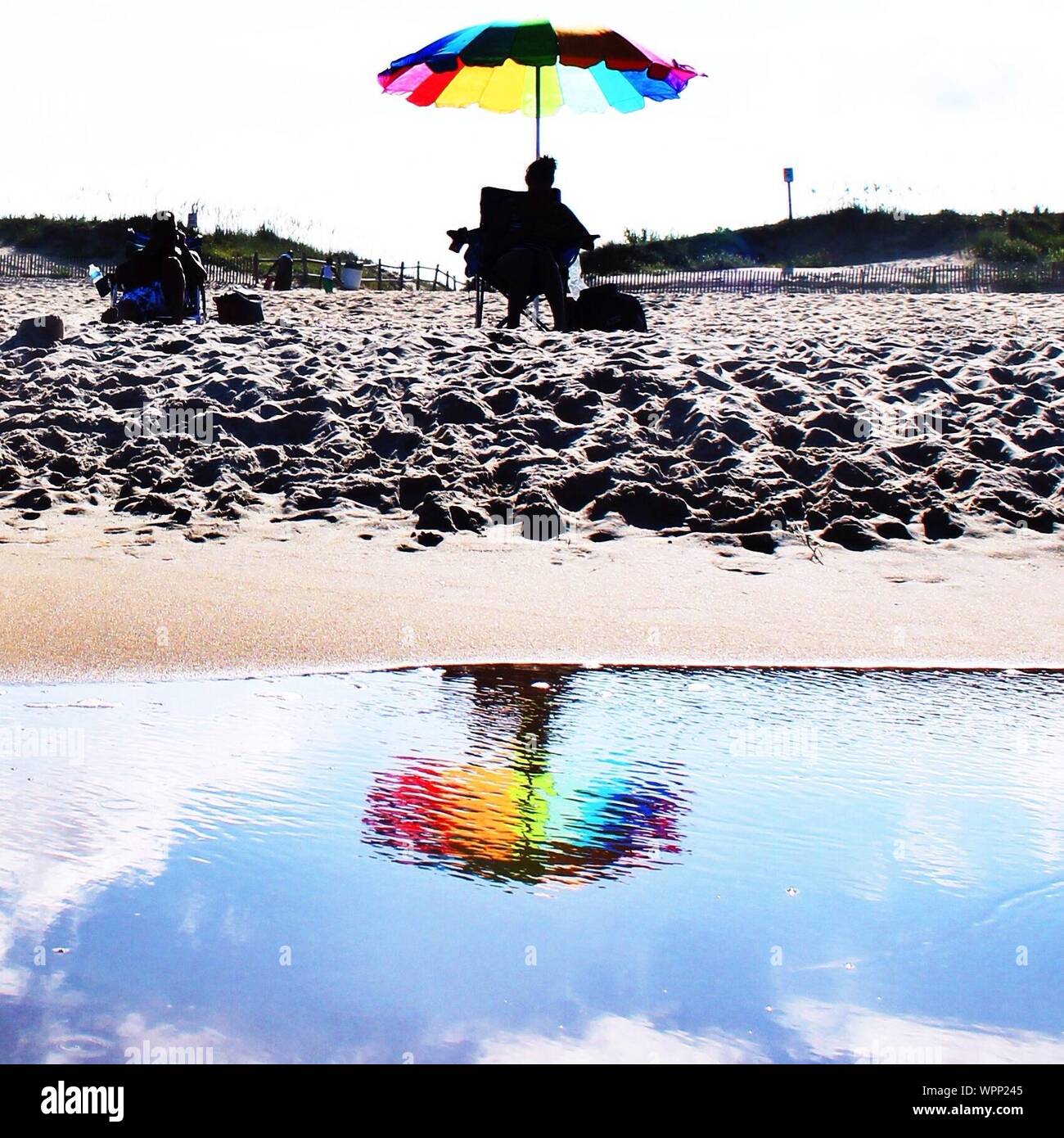 Sitting under beach umbrella hi-res stock photography and images - Alamy