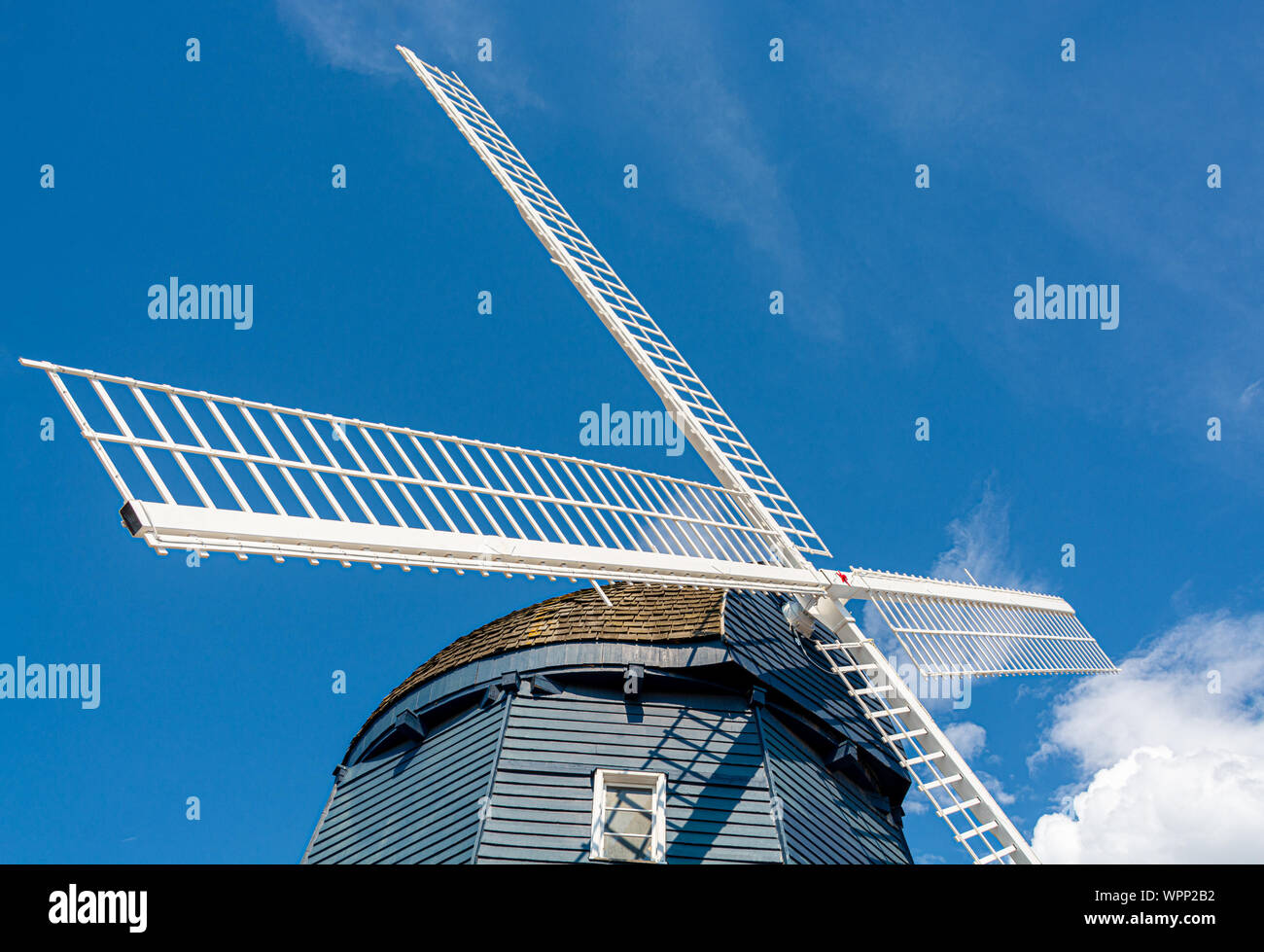 Top of vintage wind mill decorated with lights on blue sky background ...