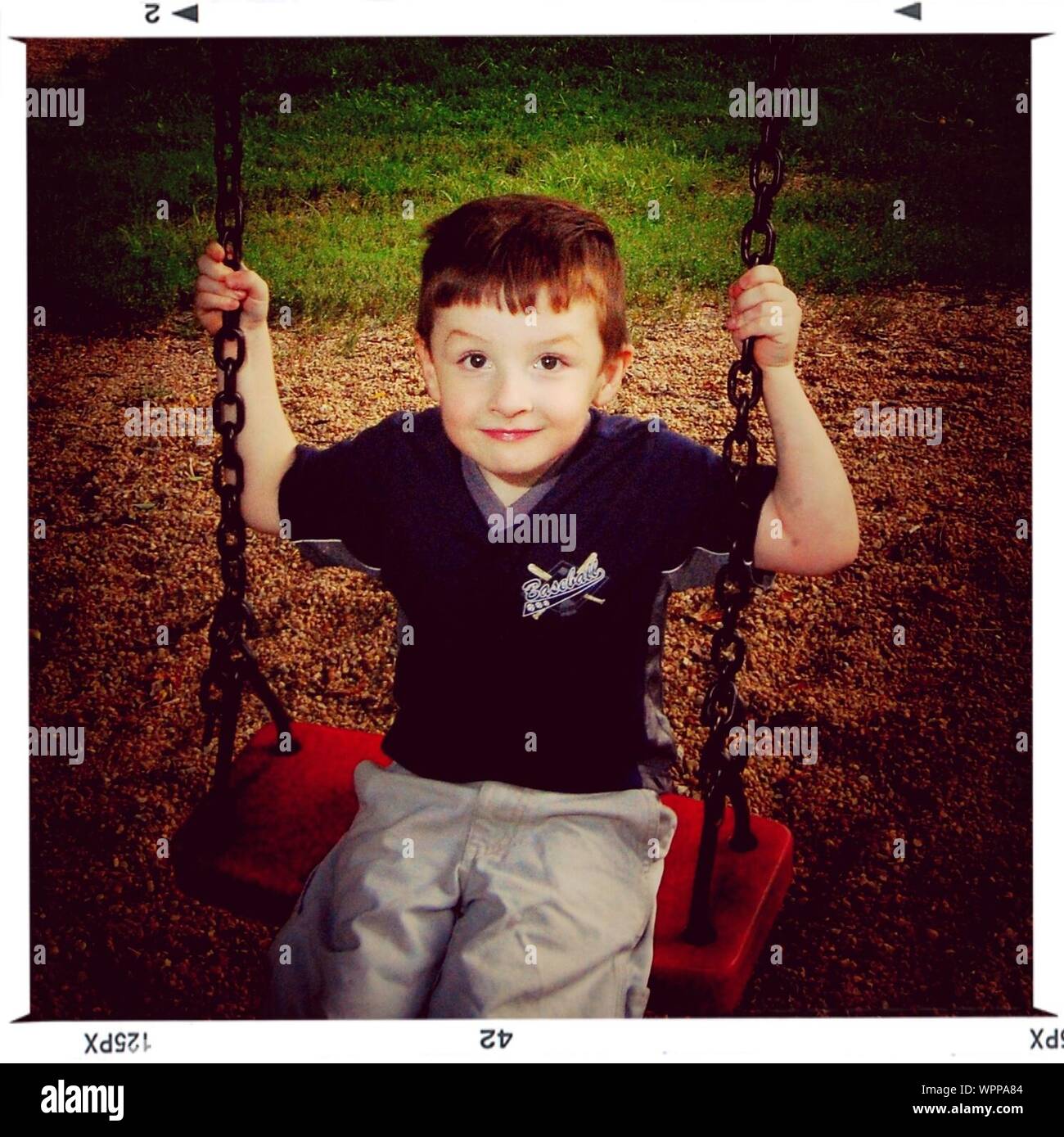 Boy smiling on swing Cut Out Stock Images & Pictures - Alamy