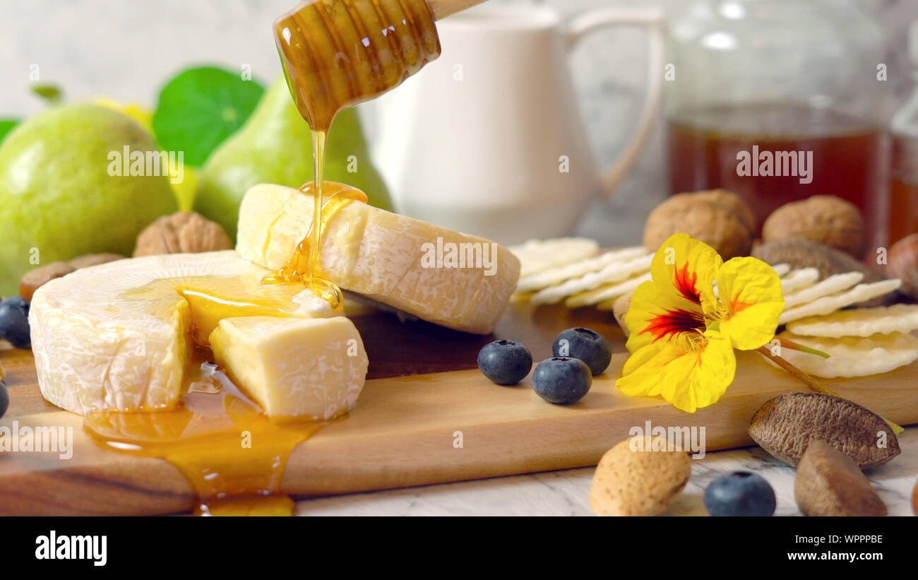 Camembert and brie cheese board with honey, fruit and nuts Stock Photo ...