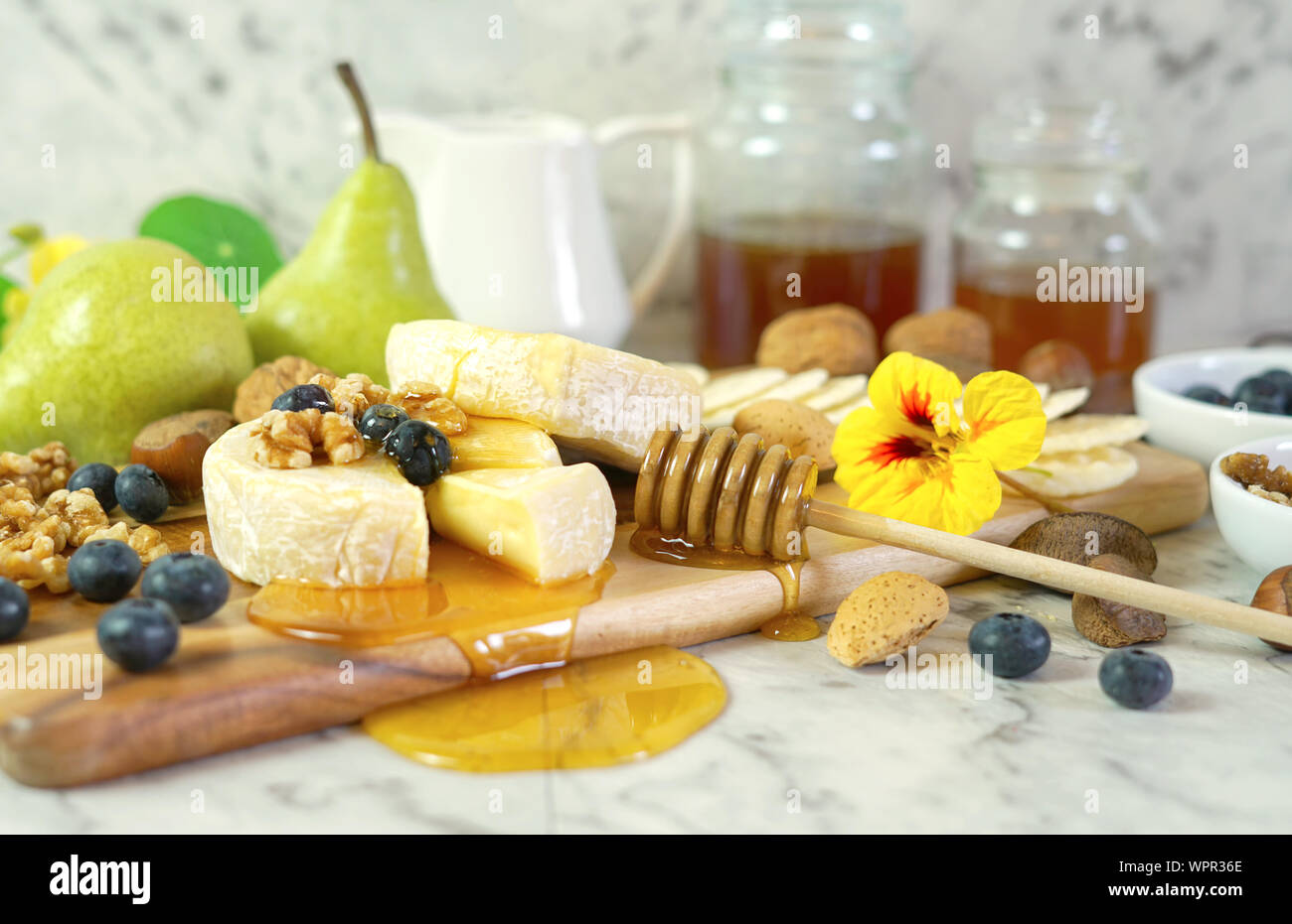 Camembert and brie cheese board with honey, fruit and nuts Stock Photo ...