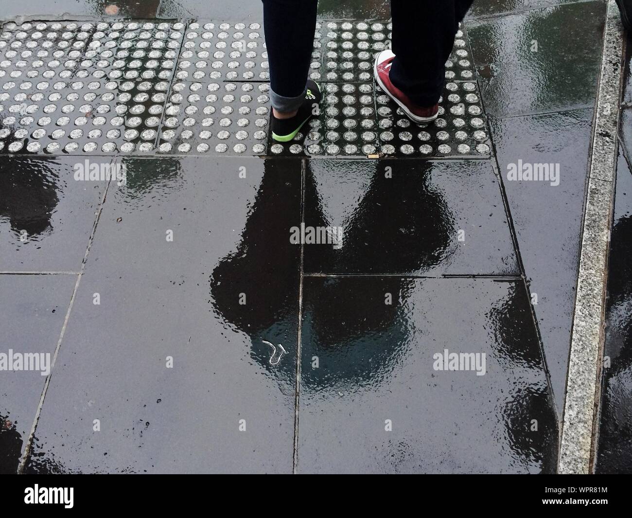 Two Feet Belonging To Different People On Edge Of Pedestrian Crossing ...