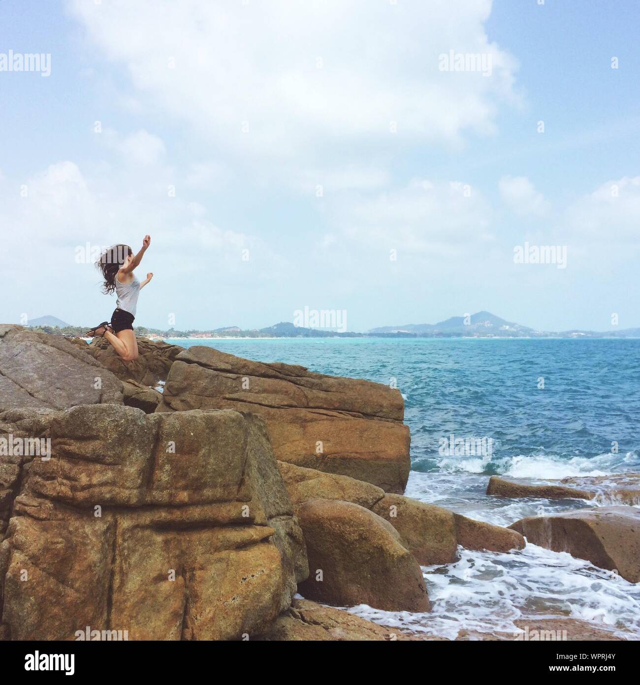 Woman jumping rock formation hi-res stock photography and images - Alamy