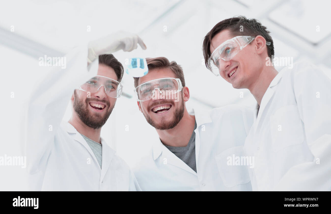 group of scientists studying the liquid in the beaker. photo with copy ...