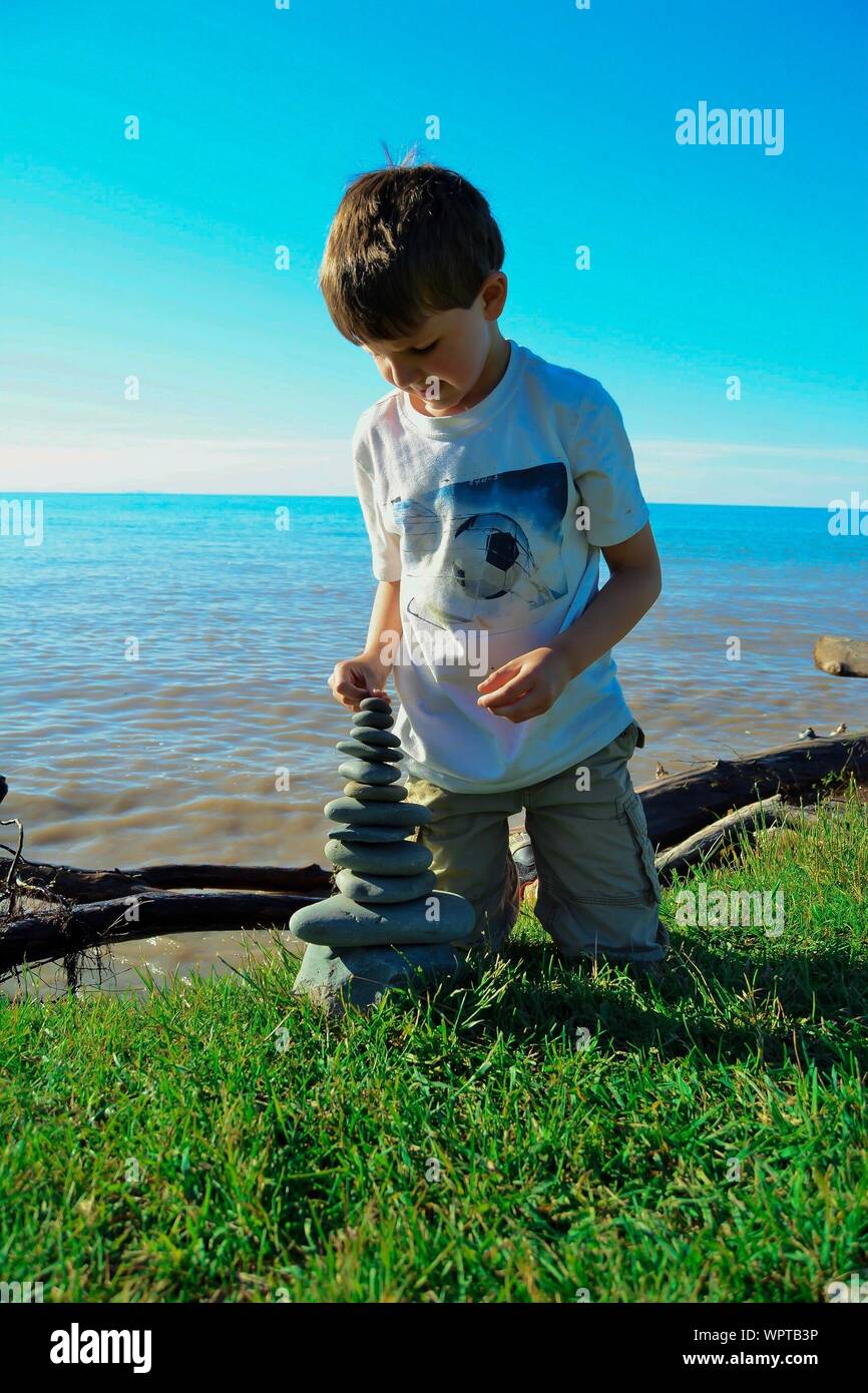 Boy playing with stones hi-res stock photography and images - Alamy