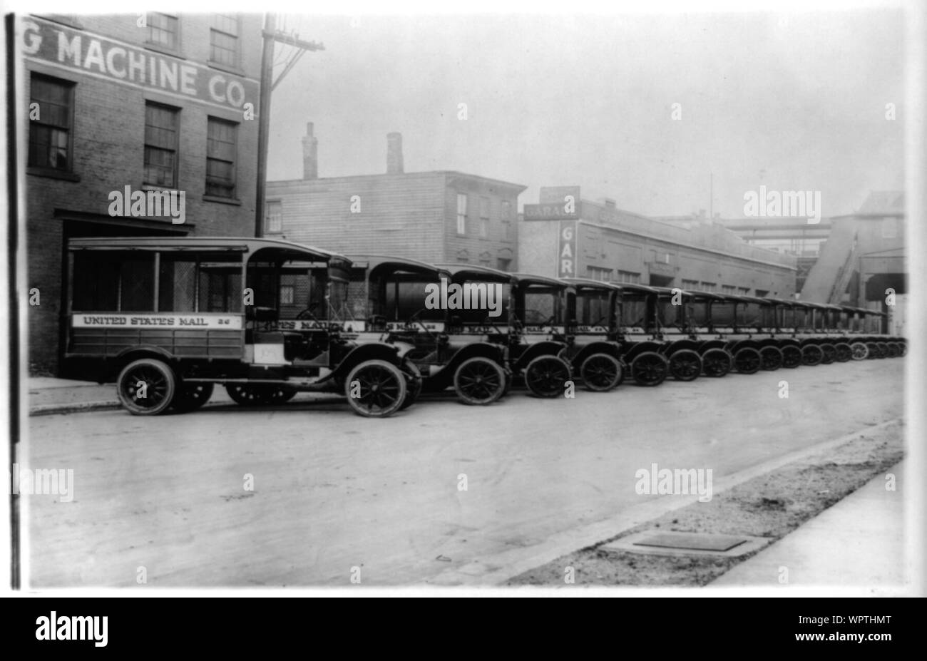 Mail trucks parked in a row in front of commercial buildings Stock ...