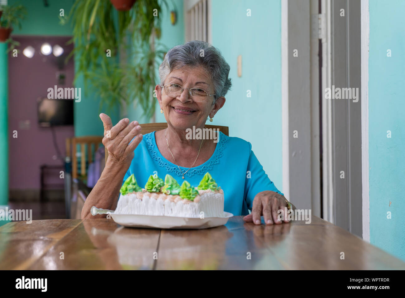 Elderly wrinkled woman sitting and a cake on table Stock Photo - Alamy