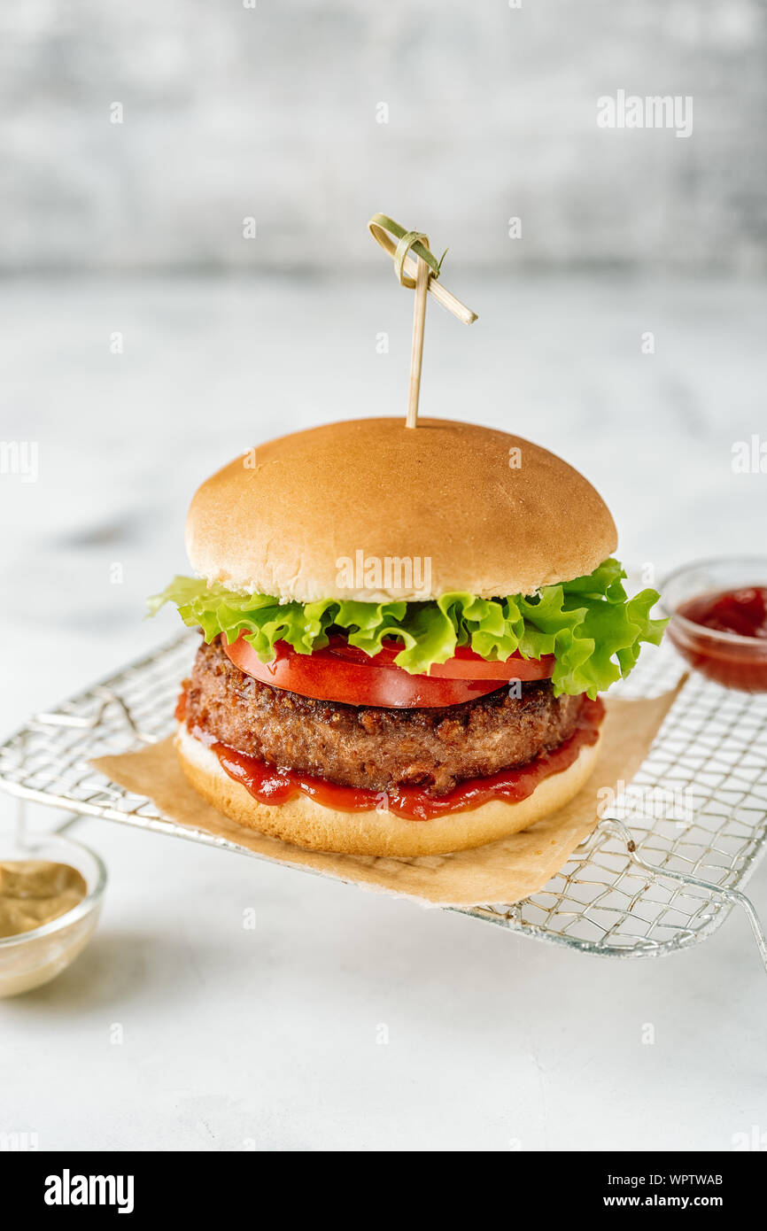 Vegan burger on white rustic background. Vertical shot Stock Photo - Alamy