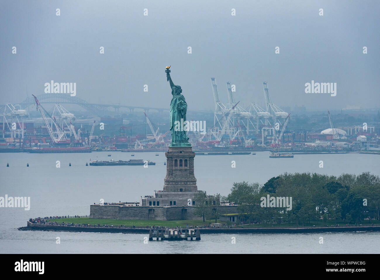 Statue of Liberty with container port in background. New York, USA ...